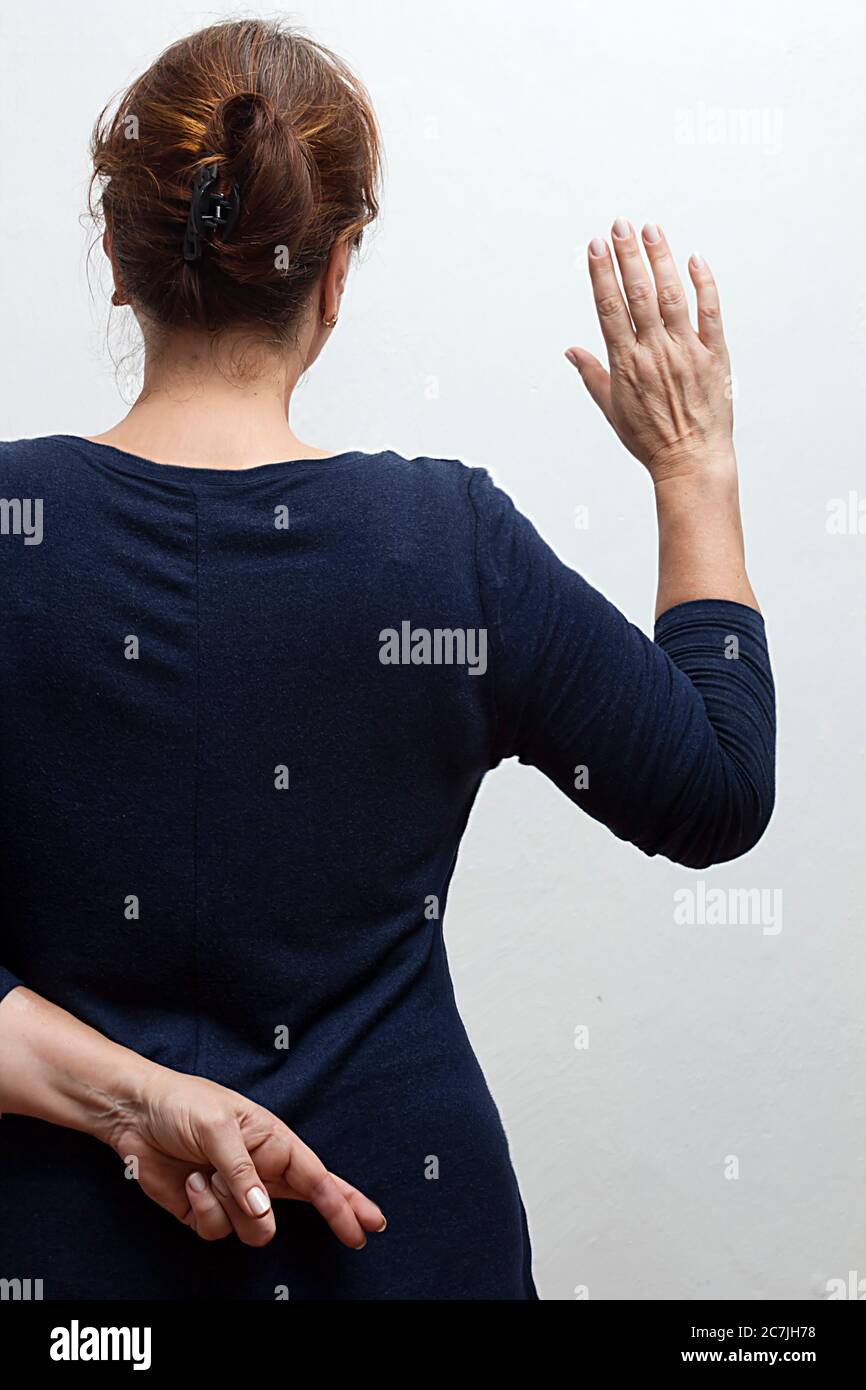 Woman takes an oath and holds her crossed fingers behind her back Stock ...