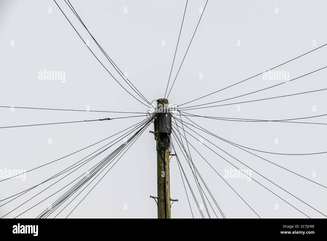 Old overhead power line with a white background Stock Photo - Alamy