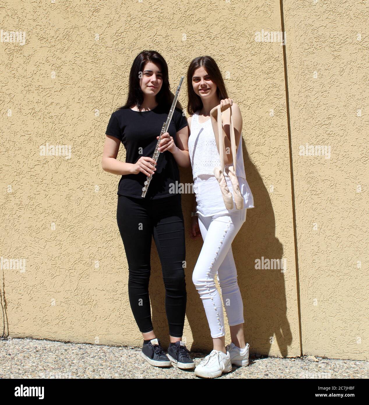 Two girls dressed in black and white clothes with flute and dance shoes ...