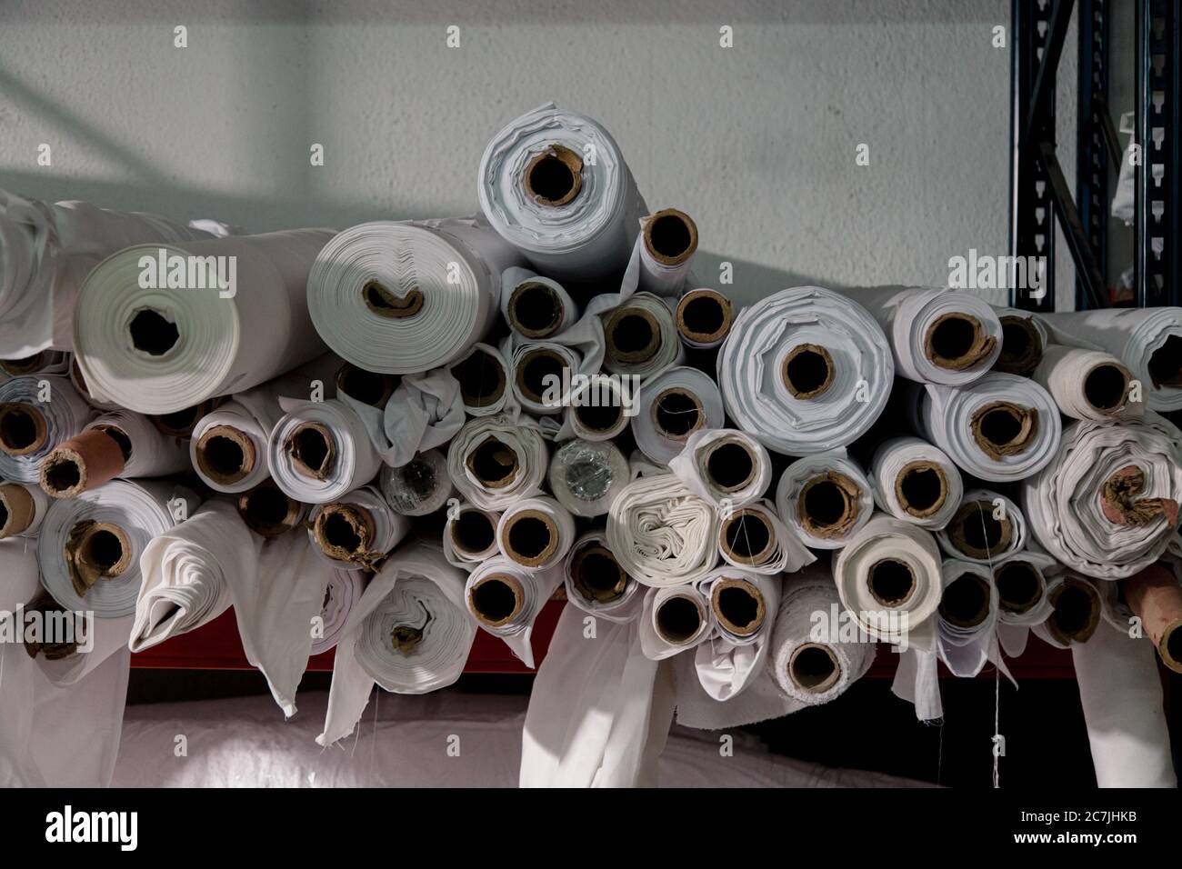 Lot of white textile rolls in a tailors studio Stock Photo - Alamy