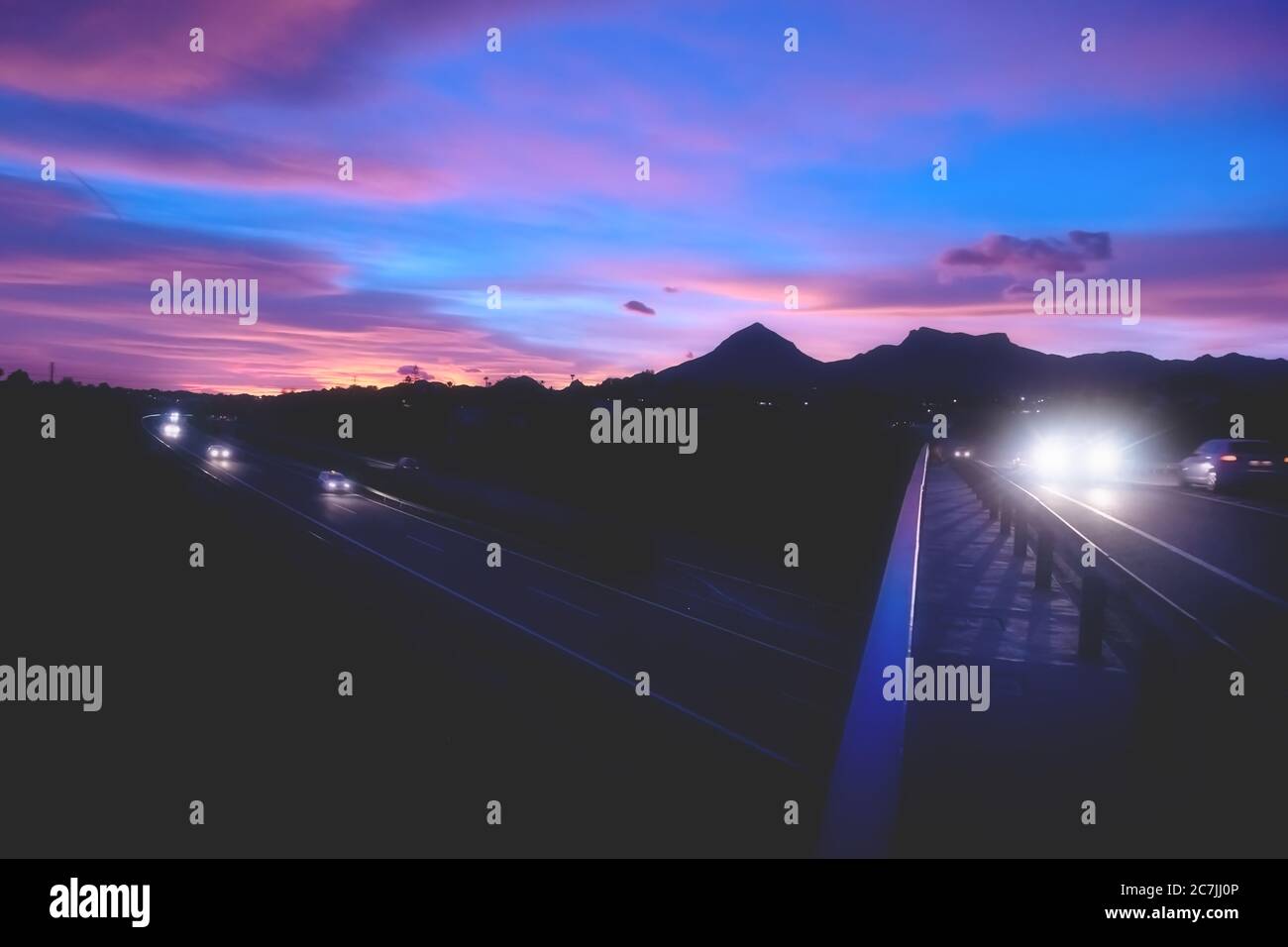 Abstract blurred mountain panorama of highway with lightening cars ...