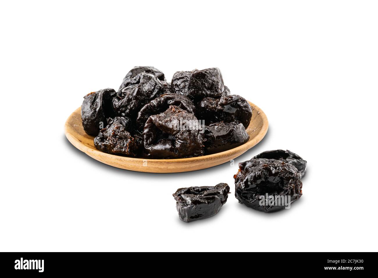 Dried pitted Prunes in wooden plate and on the floor over white ...