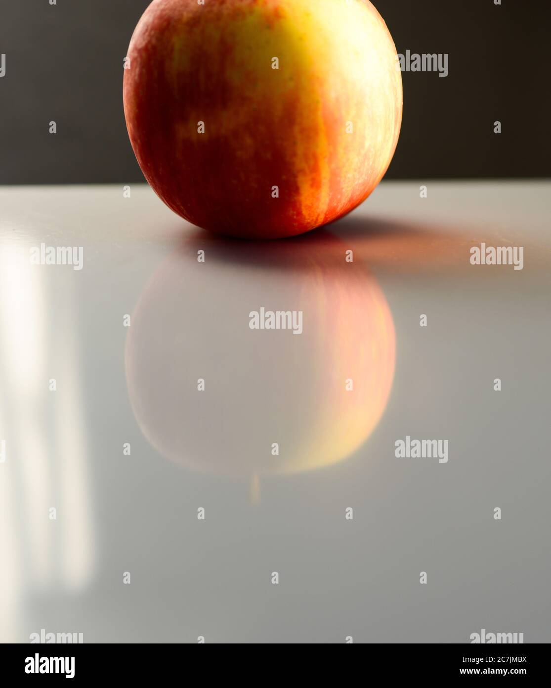 Closeup of a red apple reflecting on the table under the lights with a ...