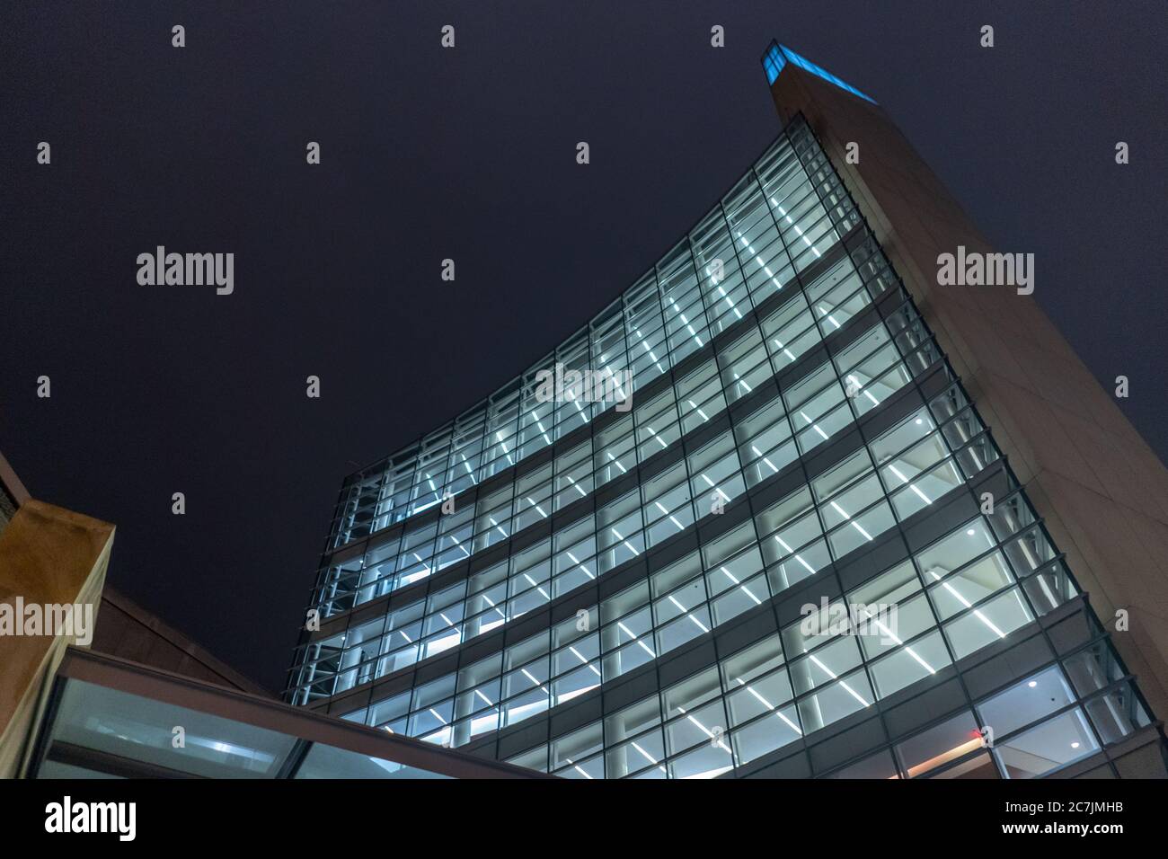 Low angle view of a modern building with the lights on during the night ...