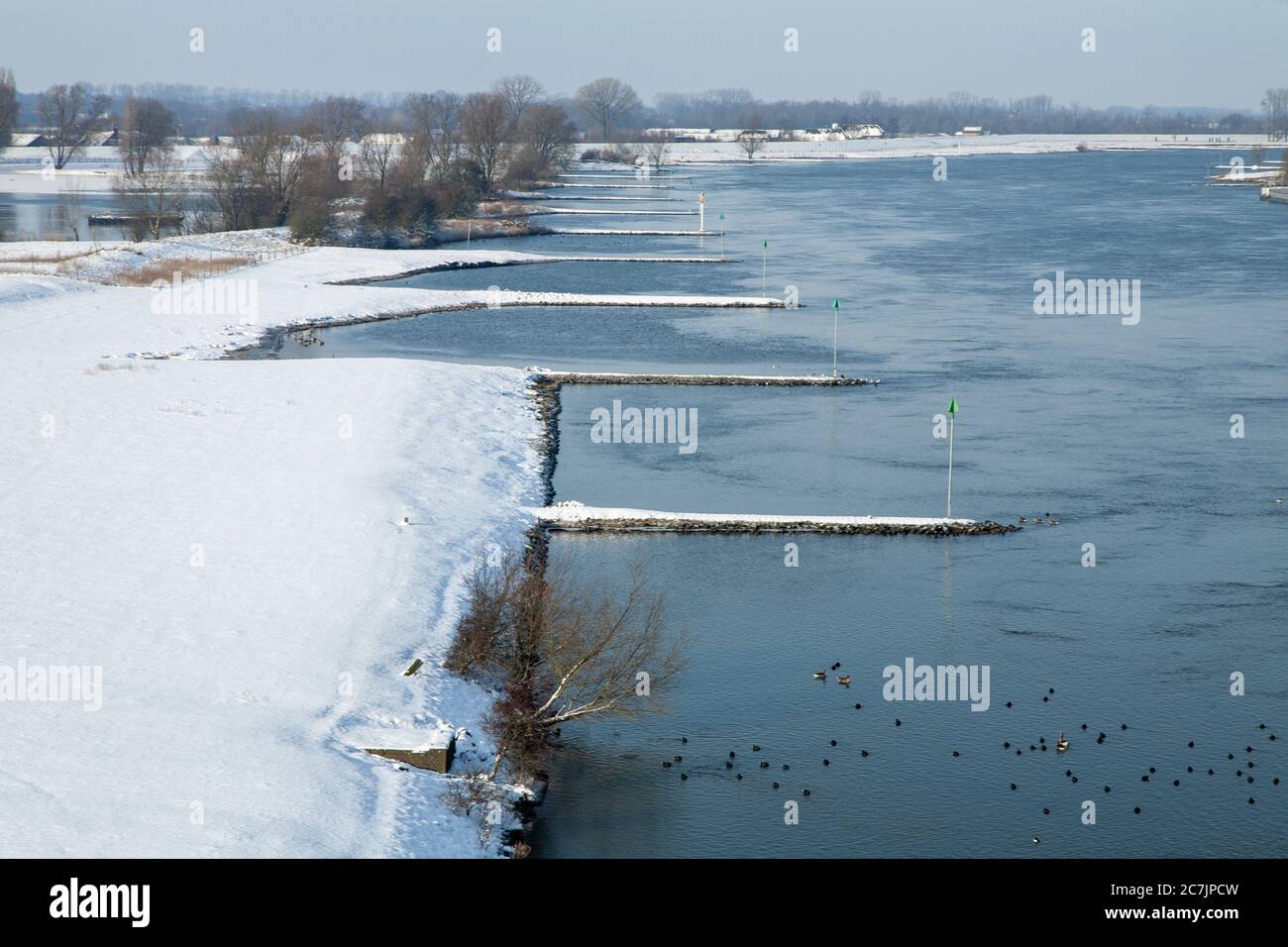 Beautiful Nederrijn river surrounded by fluffy white snow under the ...
