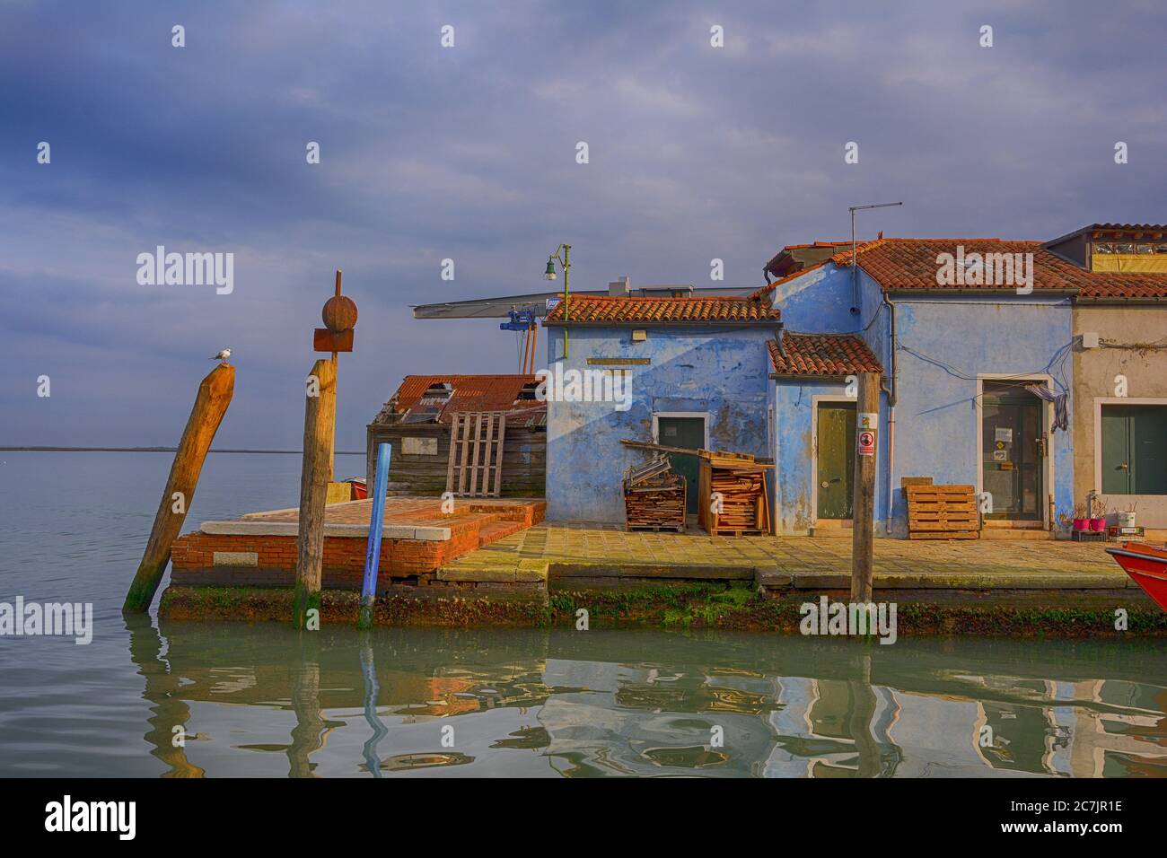Scenery of a dock with buildings at the ocean shore under the cloudy ...