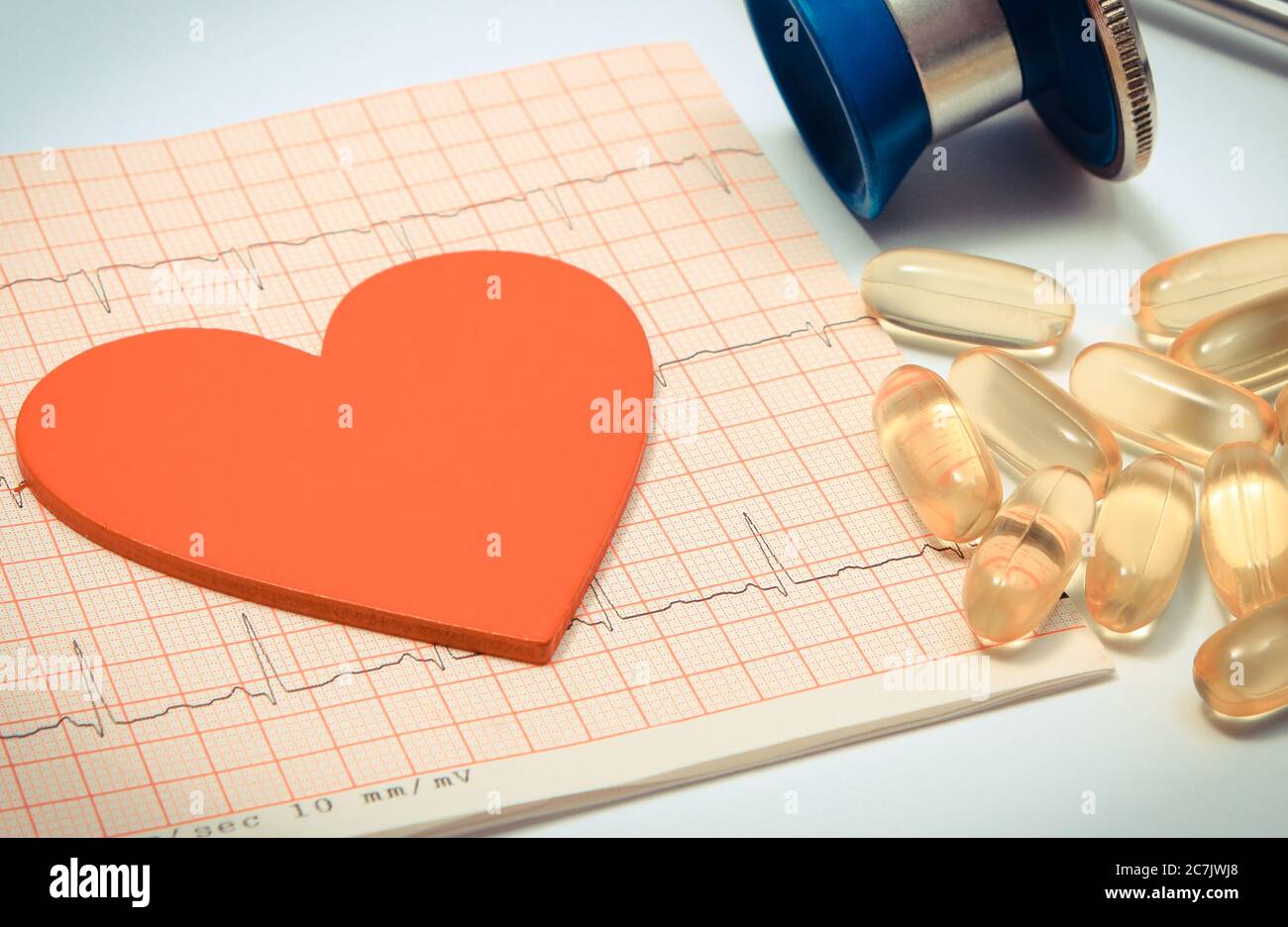Medical stethoscope, tablets and heart shape on electrocardiogram graph ...