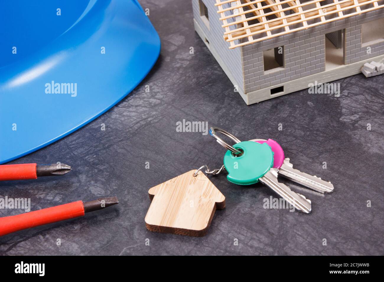Small house under construction, home keys and work tools for ...