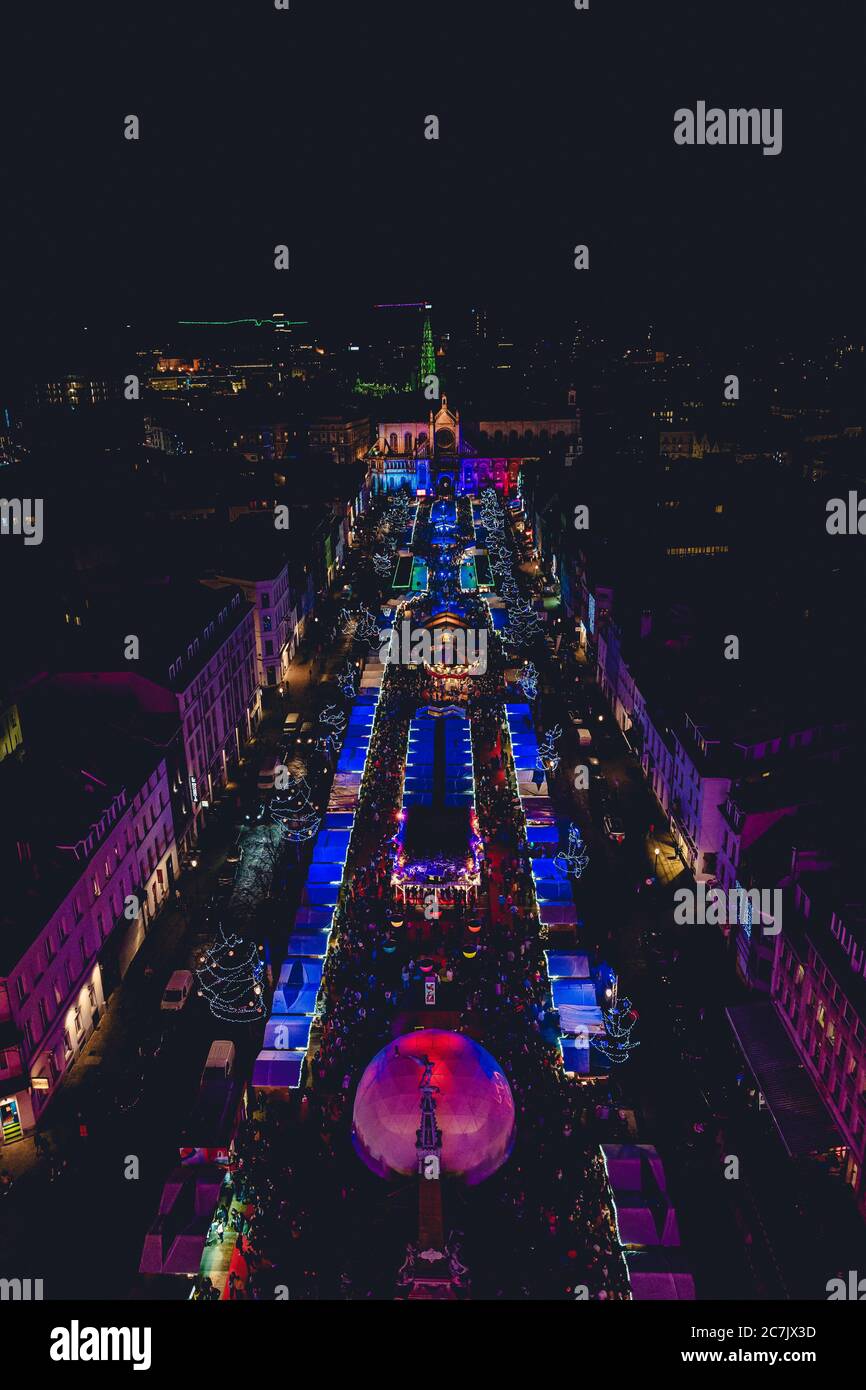 Wide angle shot of lit up buildings in a city full of people at night ...