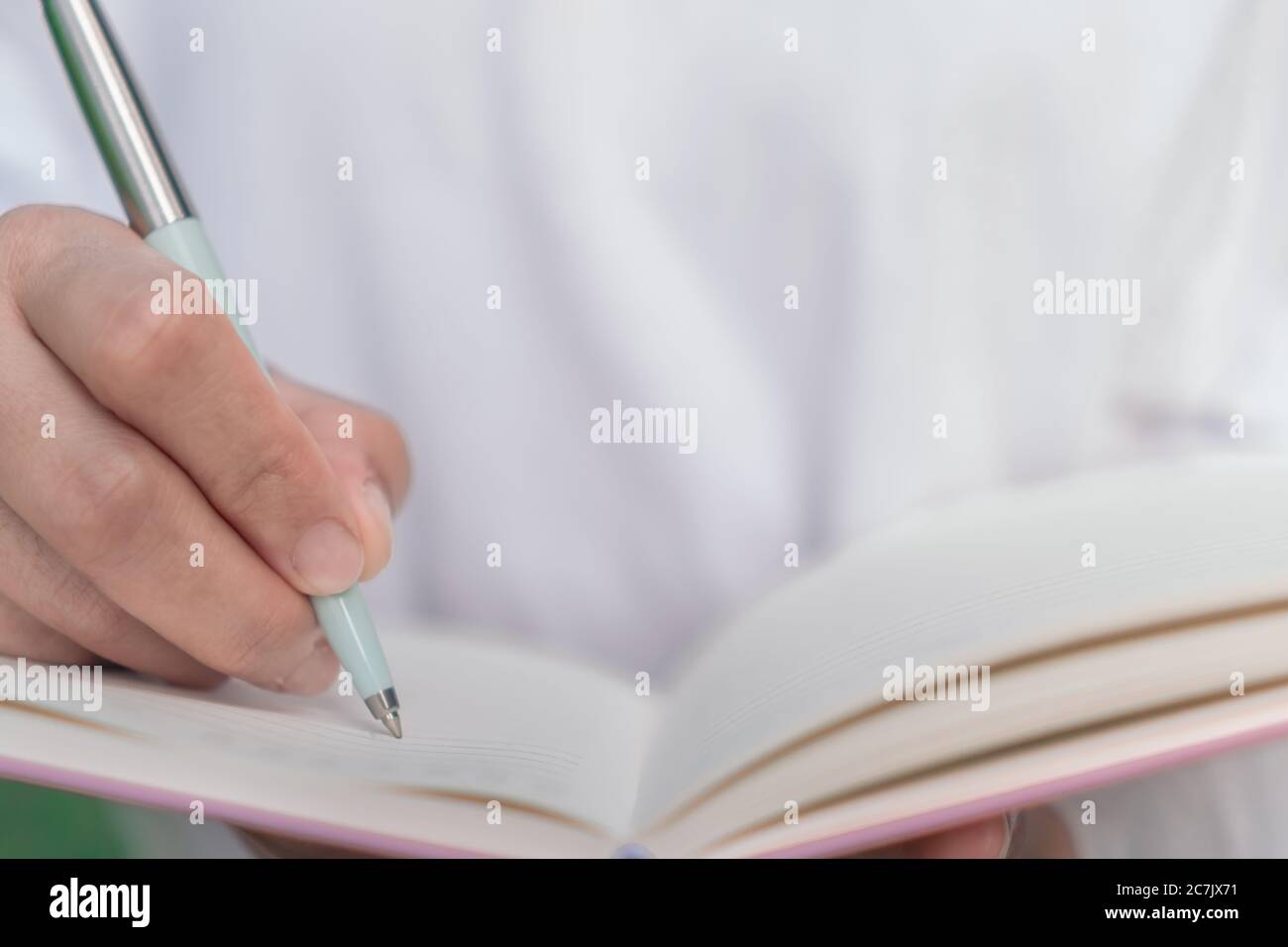 Woman hand writing down in small white memo notebook for take a note ...