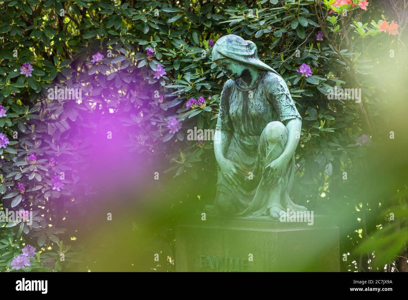 Mourning woman statue, rhododendron blossom, Ohlsdorf cemetery, Hamburg ...