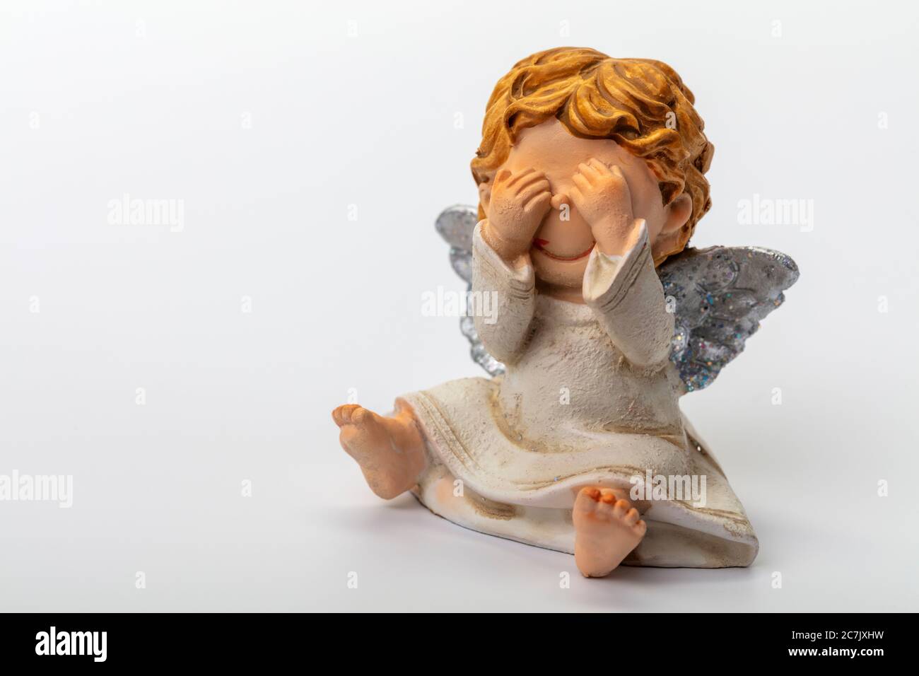 Angel covers eyes with hands, white background Stock Photo - Alamy