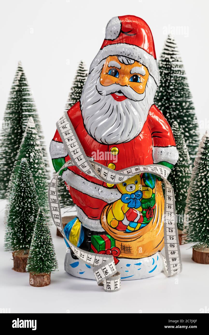 Tape measure wrapped around chocolate Santa Claus, stands in the midst ...