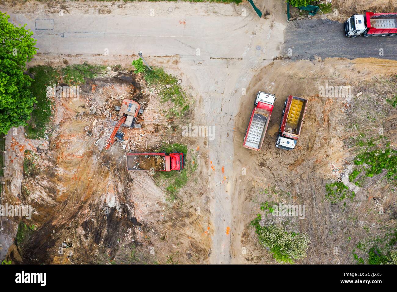demolition site aerial top view. heavy excavator loading a debris and ...