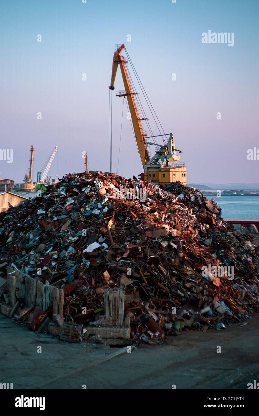 Garbage pile in trash dump or junkyard, metal crane garbage consumption ...
