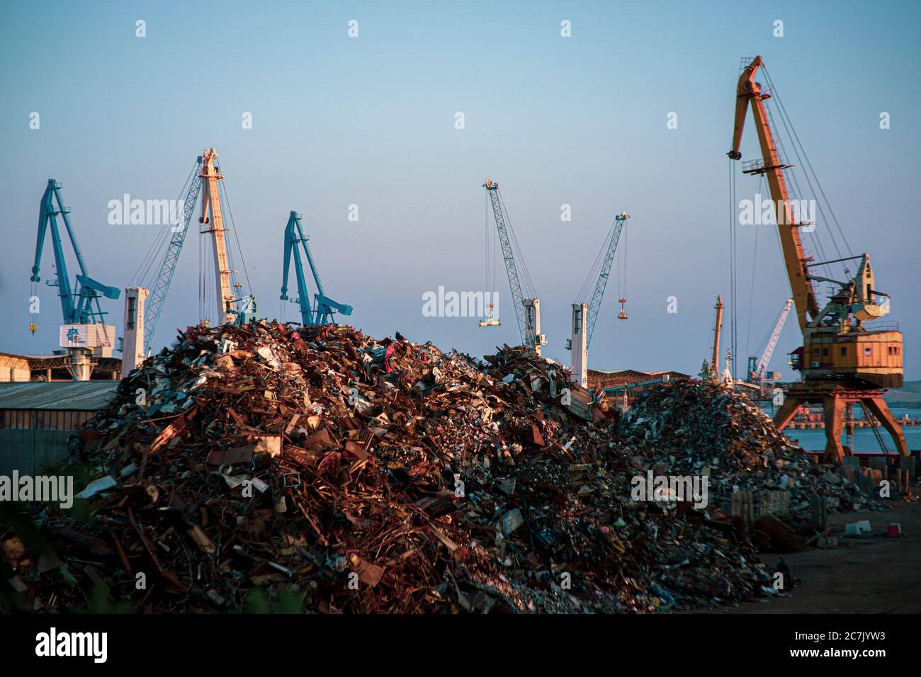 Garbage pile in trash dump or junkyard, metal crane garbage consumption ...