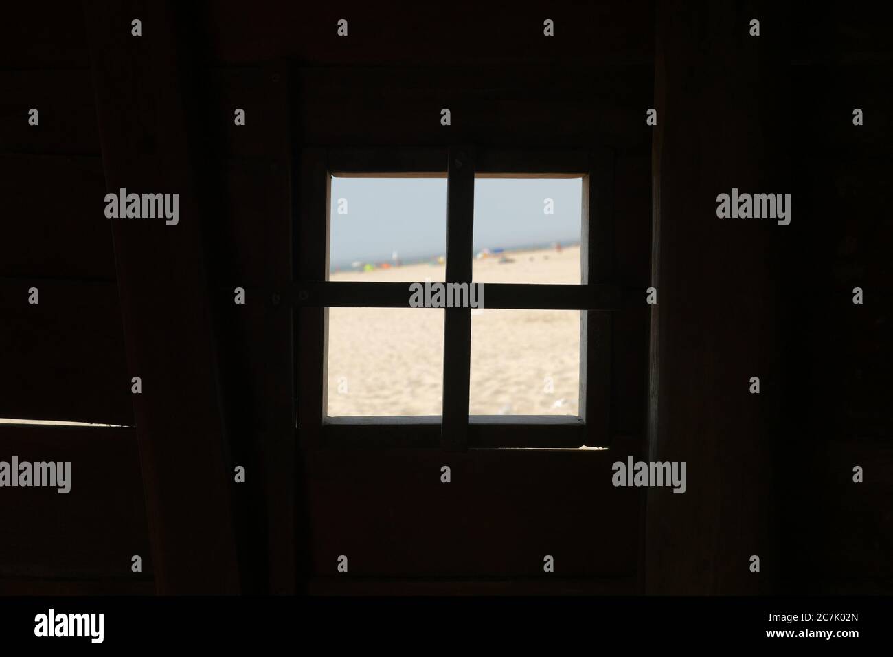Silhouette of a square-shaped window in a building with a beach view ...