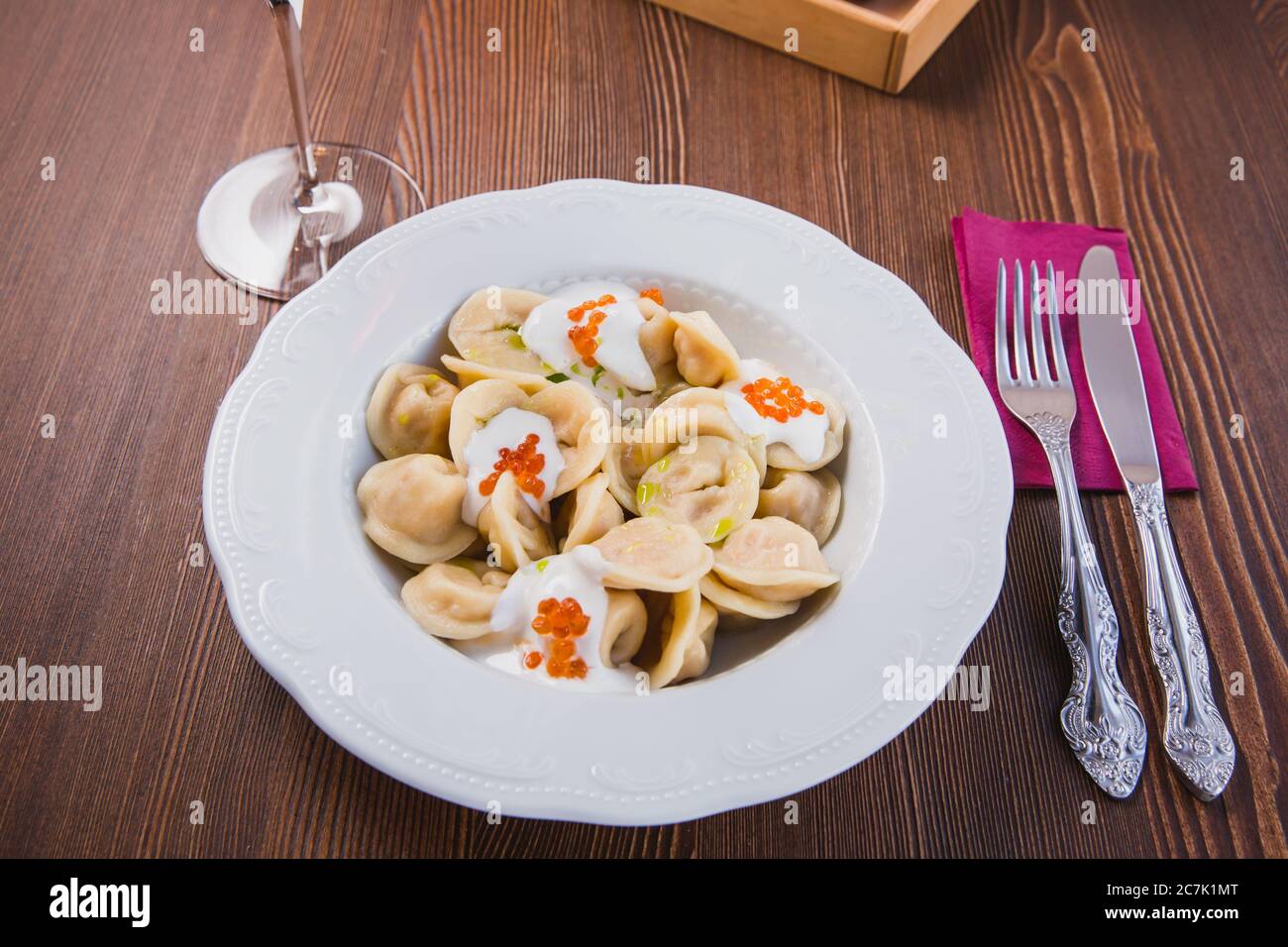 Dumplings Bowl with Red caviar and sour cream on a brown table ...
