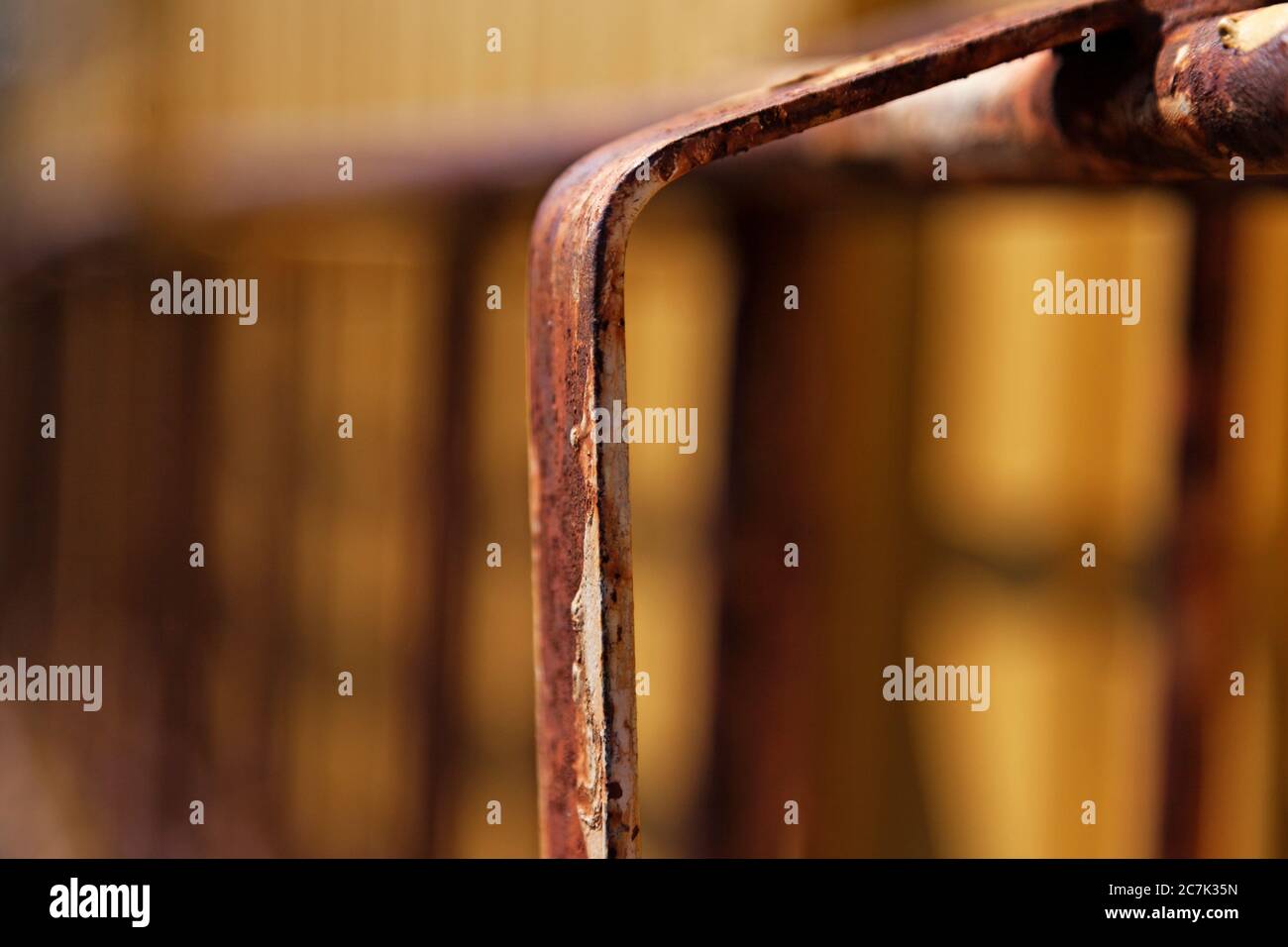 a small part of a rusty ladder hanging on a yellow house wall Stock ...