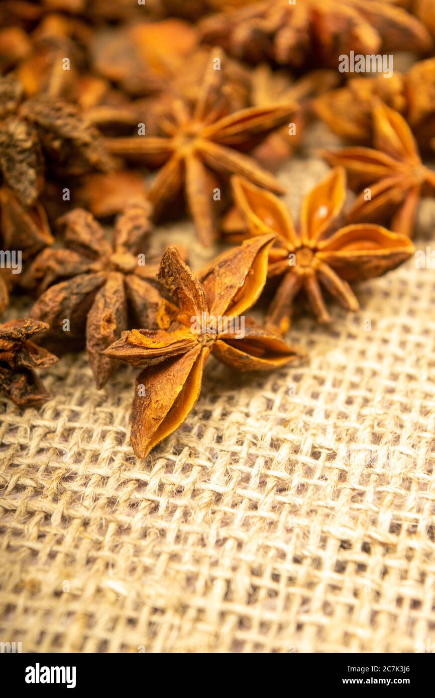 A pile of star anise on a background of burlap with a rough texture ...