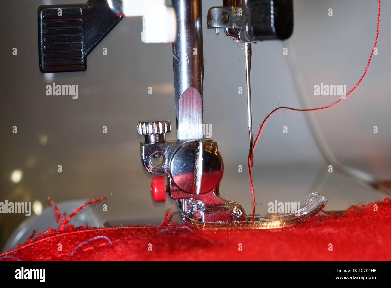 Sewing on sewing machine with red cloth and red thread Stock Photo - Alamy
