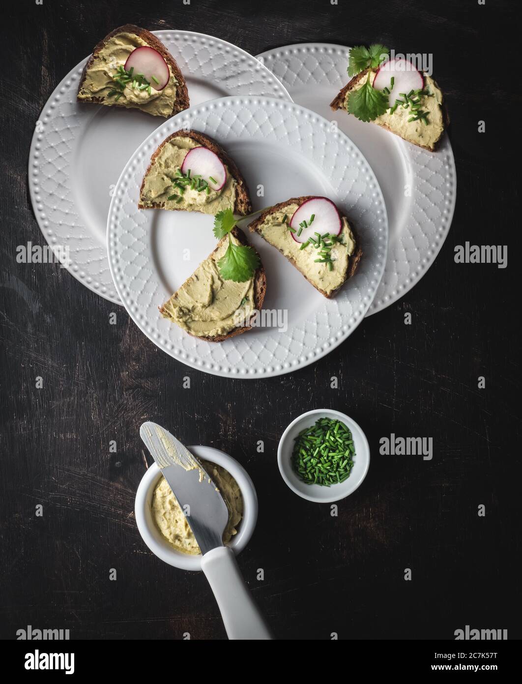 Bread Bread with avocado spread, radishes and fresh chives on three ...