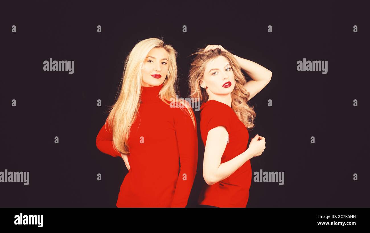 Portrait of pretty women friends posing against black background Stock ...