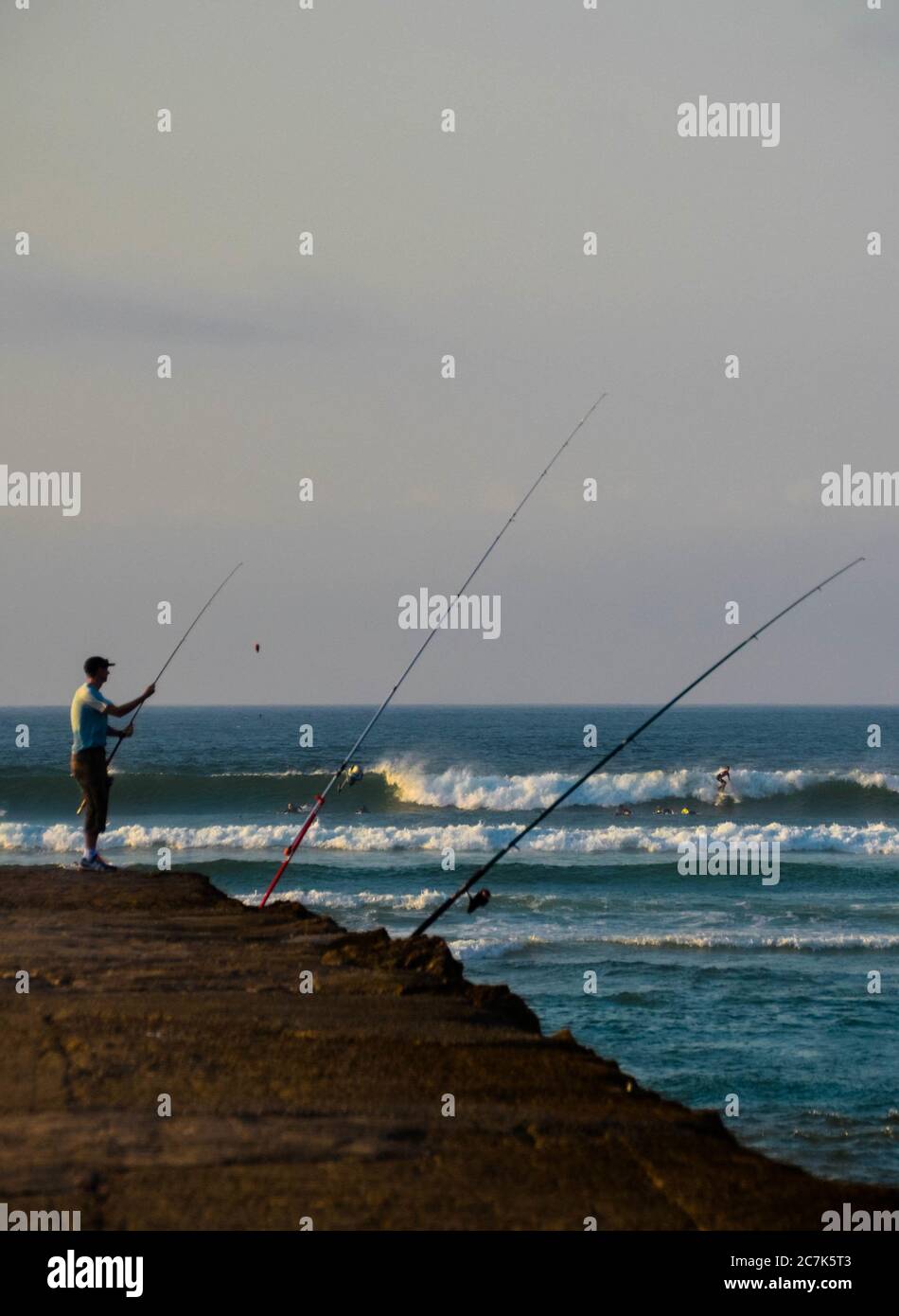 Vertical shot of a fisherman catching fish from the sea Stock Photo - Alamy