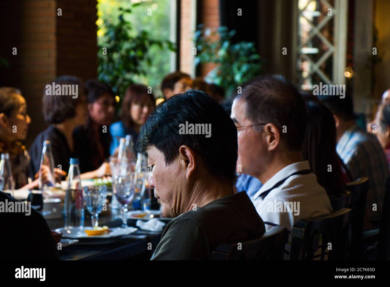 TBILISI, GEORGIA - JULY 14, 2019: Asian tourists eating, sitting and ...