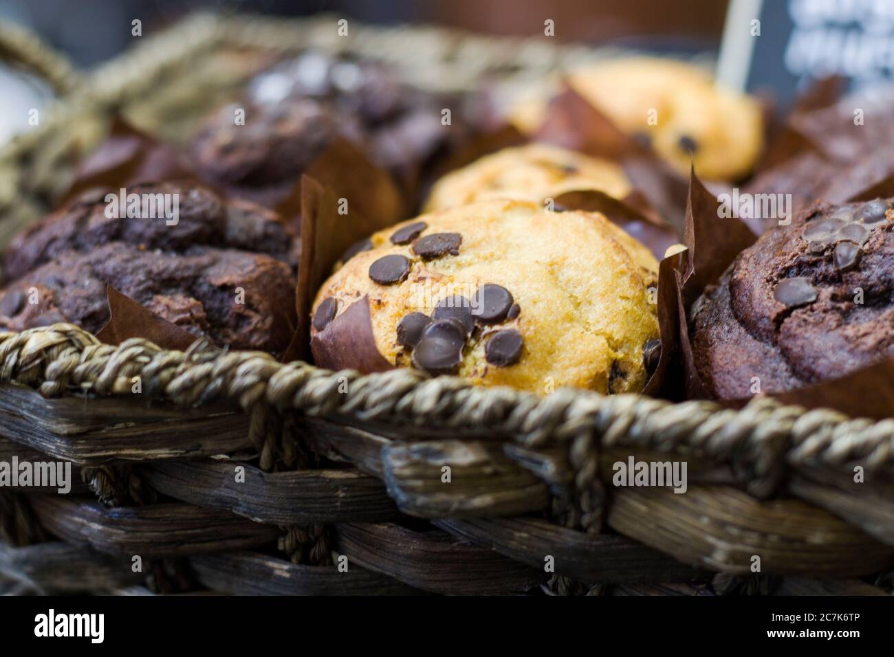 Large group of muffins in wooden bowl with chocolate and name letter ...