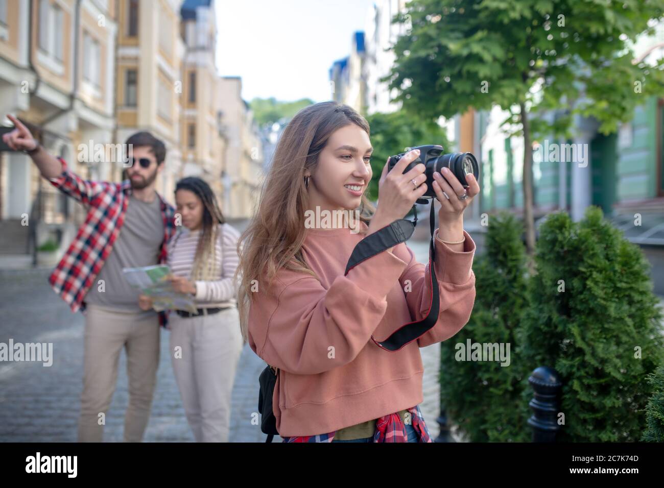 Girl looking at camera, guy with girlfriend with map at distance Stock ...