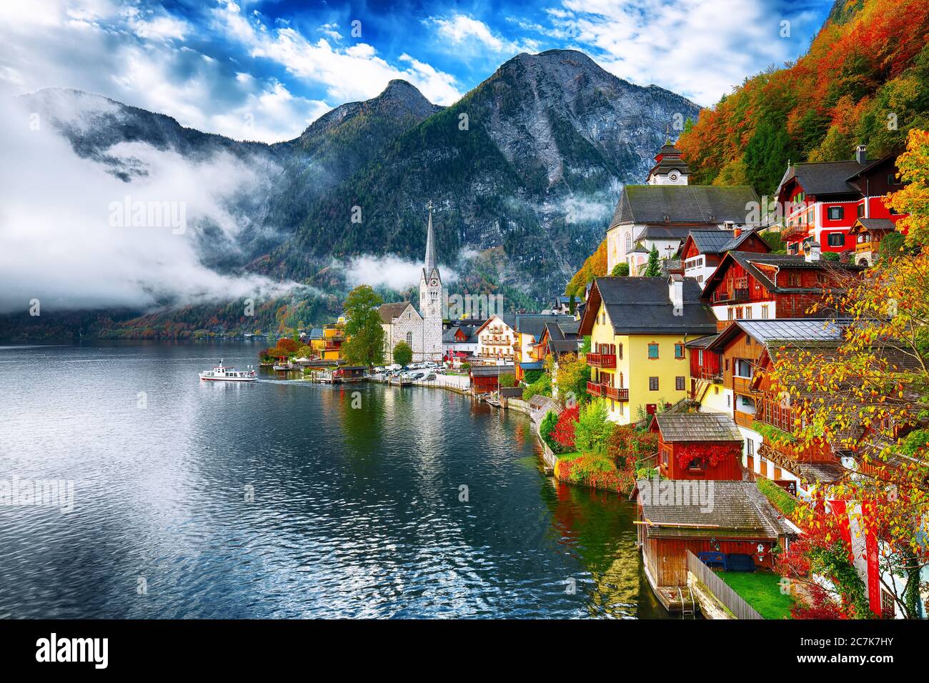 Scenic view of famous Hallstatt mountain village with Hallstatter lake. Sunny autumn sunrise on ...