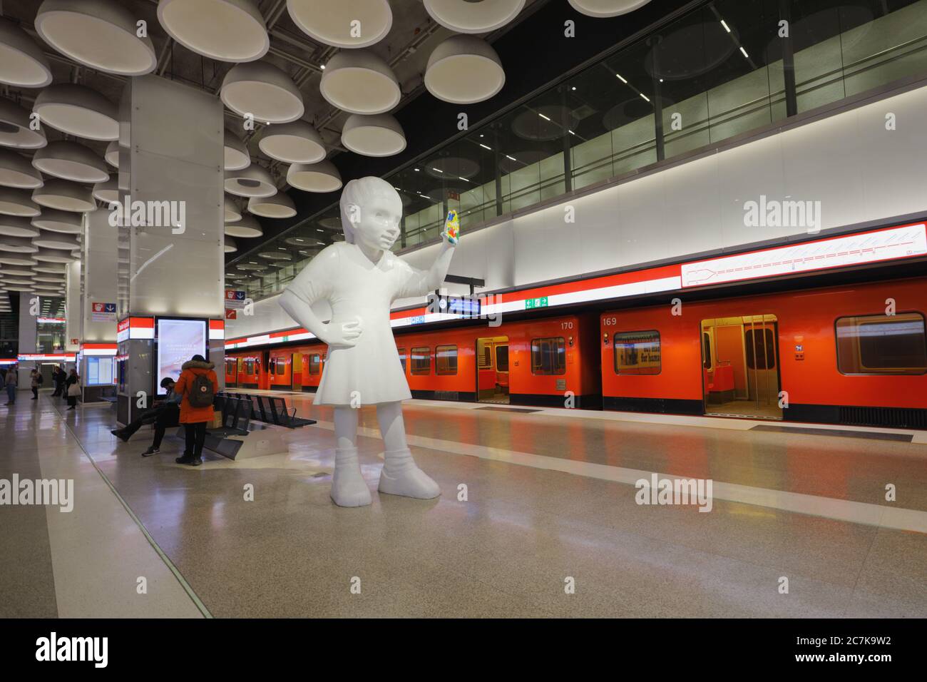 Train arriving on the station Tapiola of Helsinki metro. Statue Emma ...