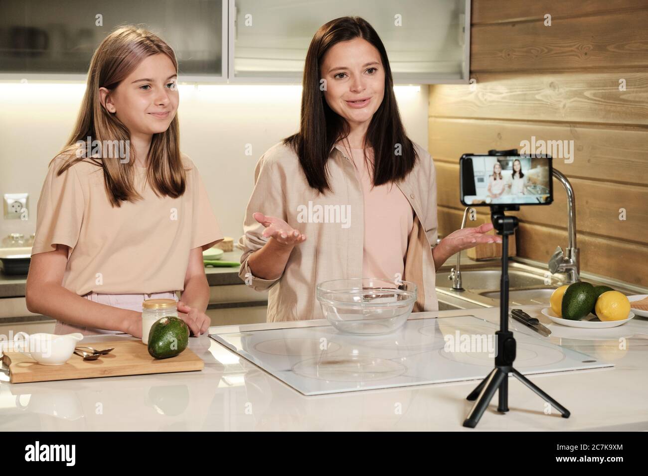 Pretty brunette female in casulawear and her teenage daughter making ...