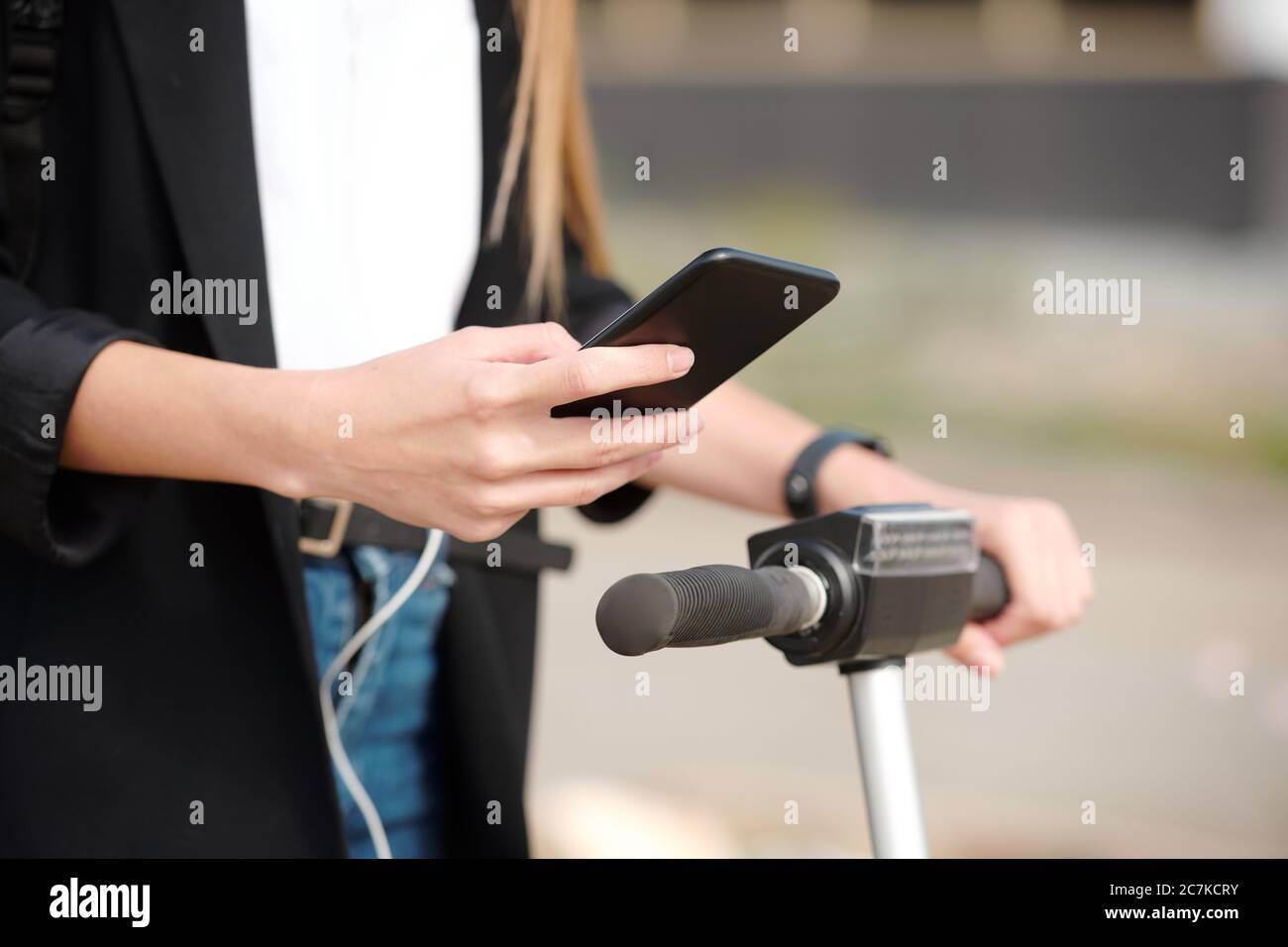 Hand of young female with mobile gadget scrolling through playlist ...