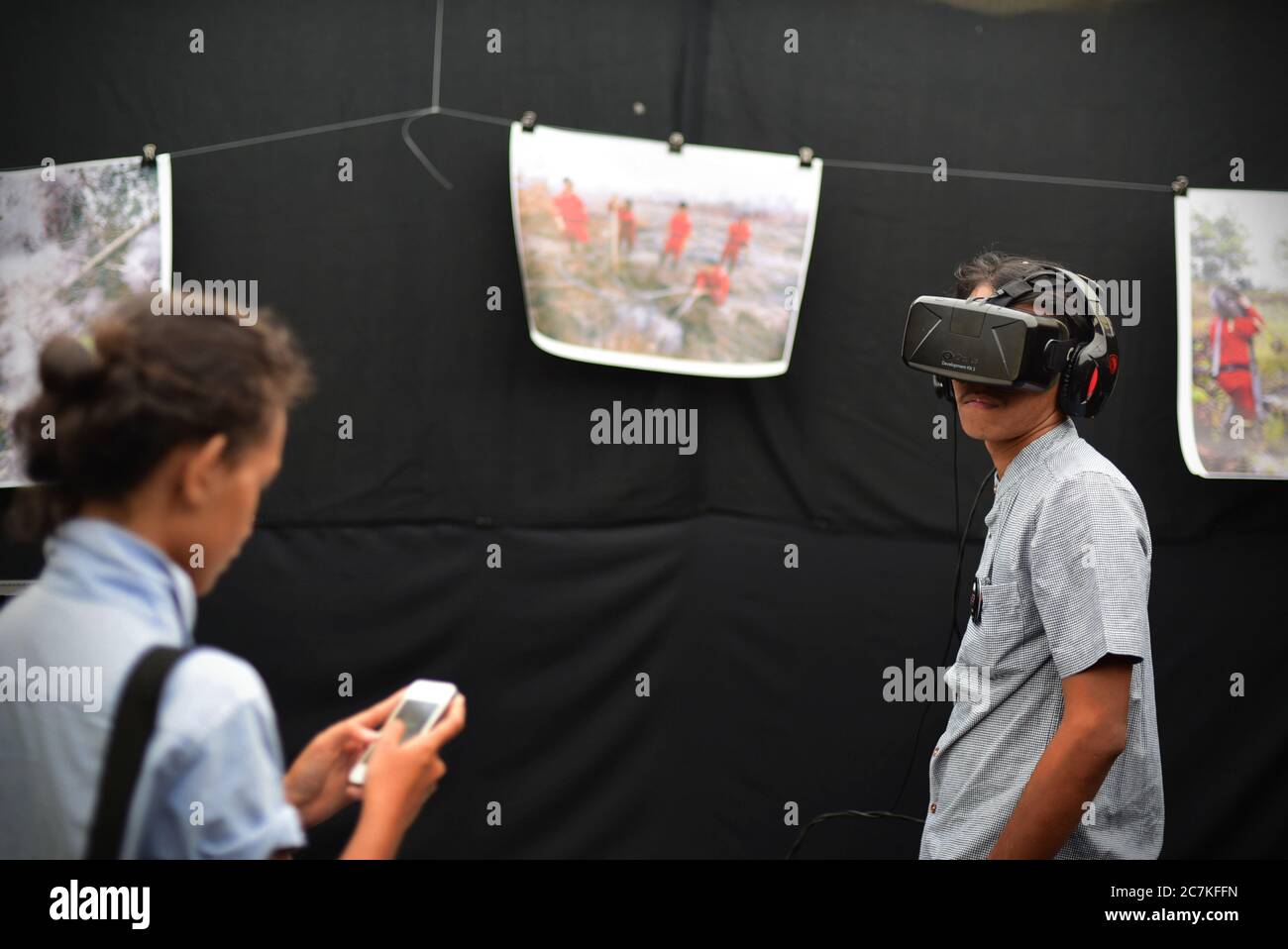 A visitor looking into a virtual reality display on tropical rainforest ...
