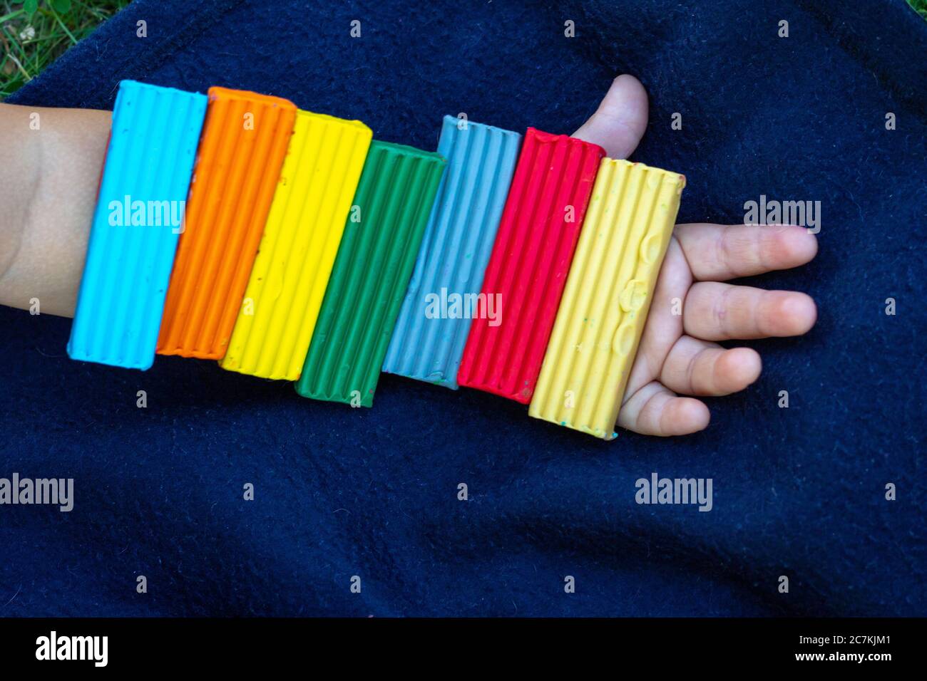Child's hand holding multi-colored plasticine, flat lay Stock Photo - Alamy