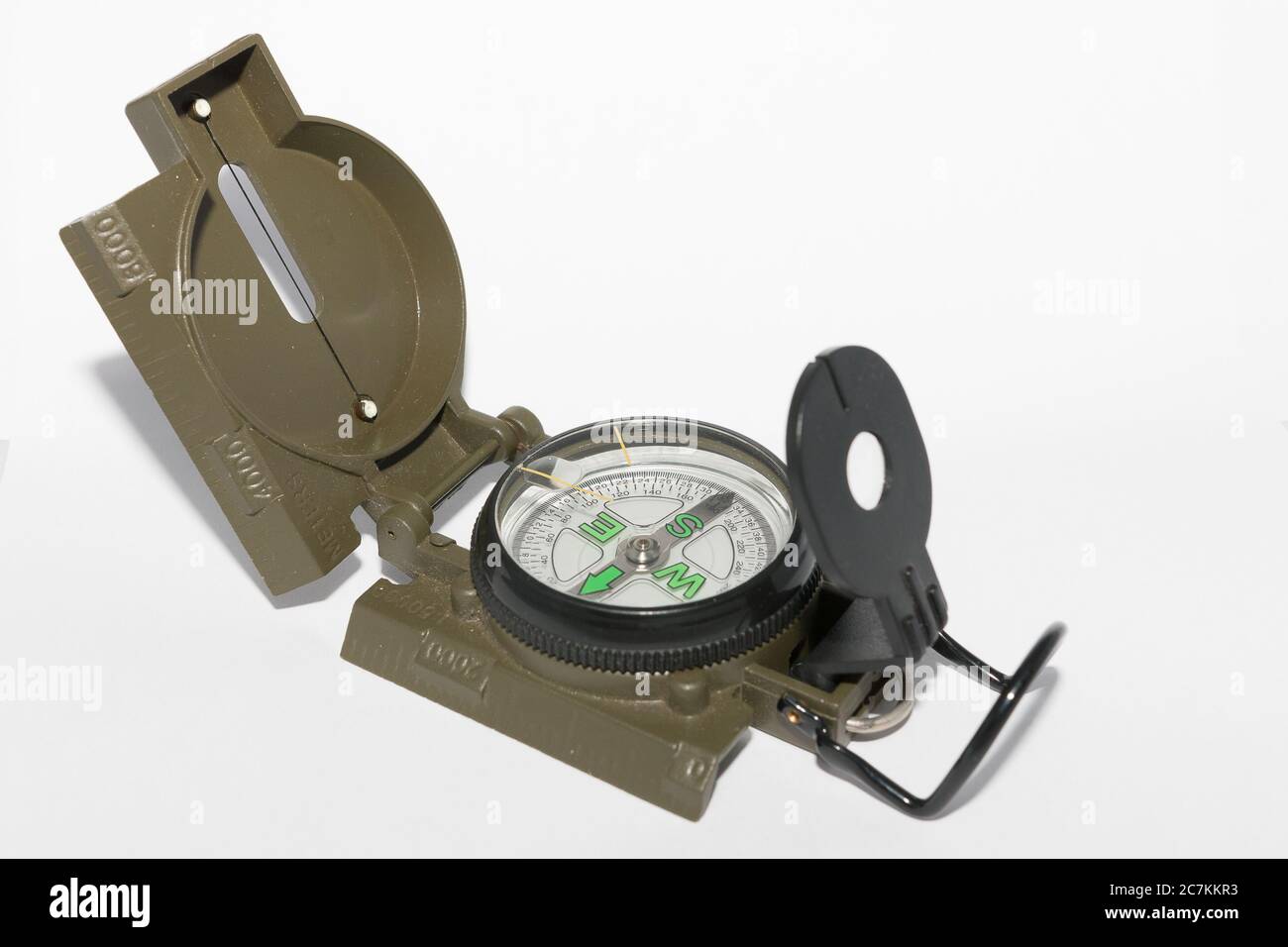 Closeup of a folding compass under the lights against a white ...