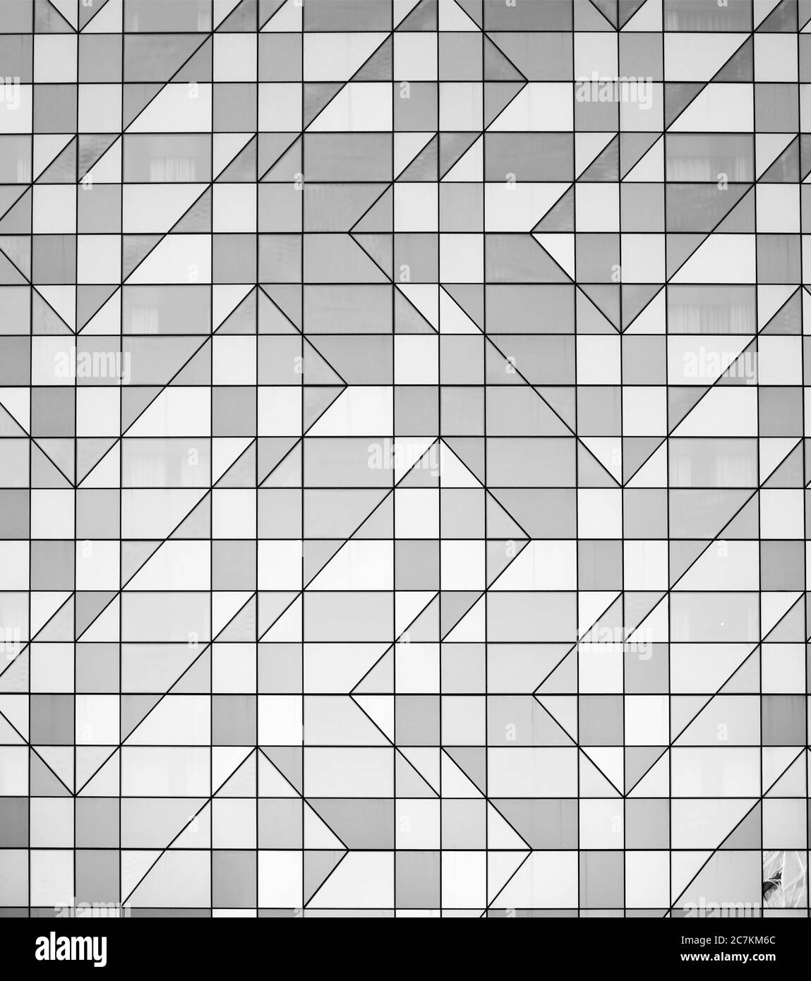 Vertical shot of a wall texture with grey and white tiles with ...