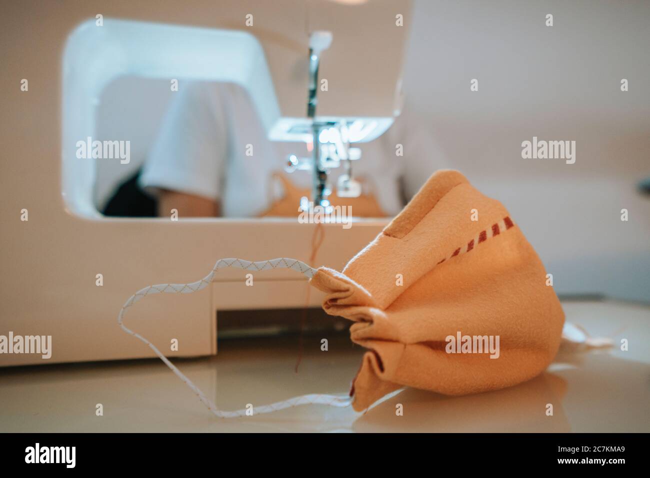 Woman sewing face mask for corona covid pandemic with sewing machine ...