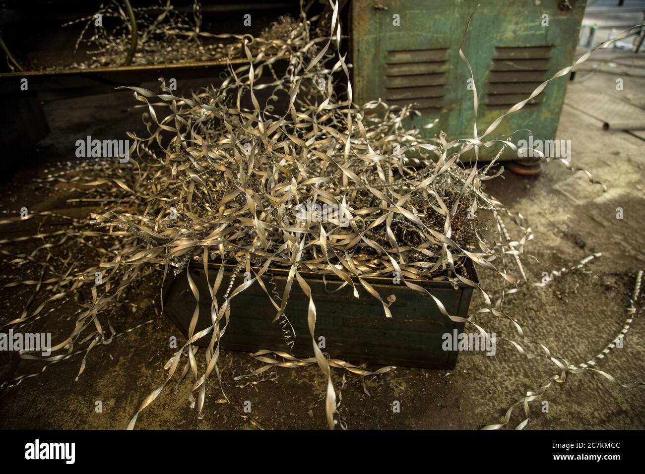 Container full of swarf on the ground under the lights with a blurred ...