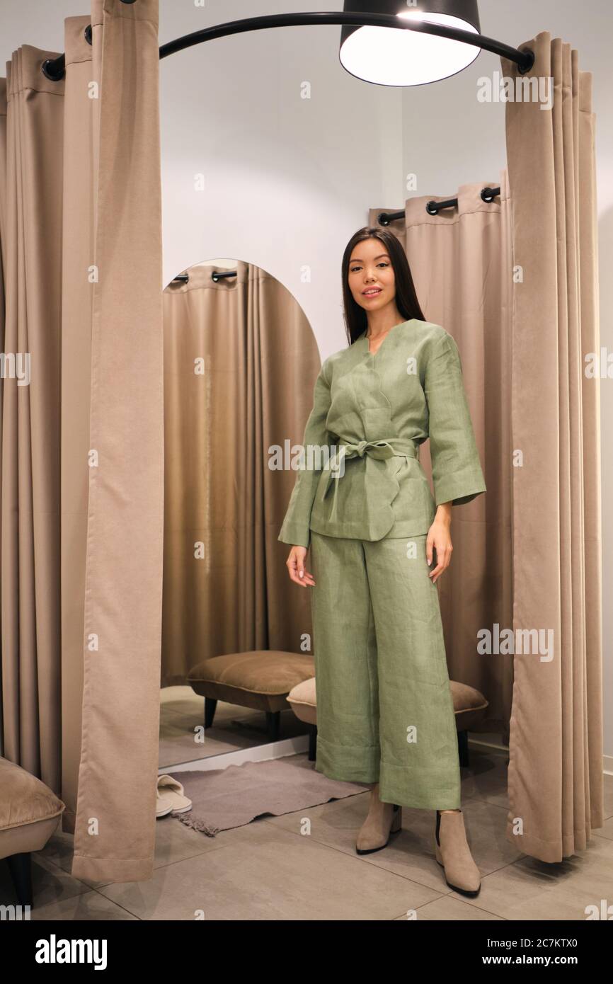 Beautiful Asian girl trying on stylish suit confidently looking in ...