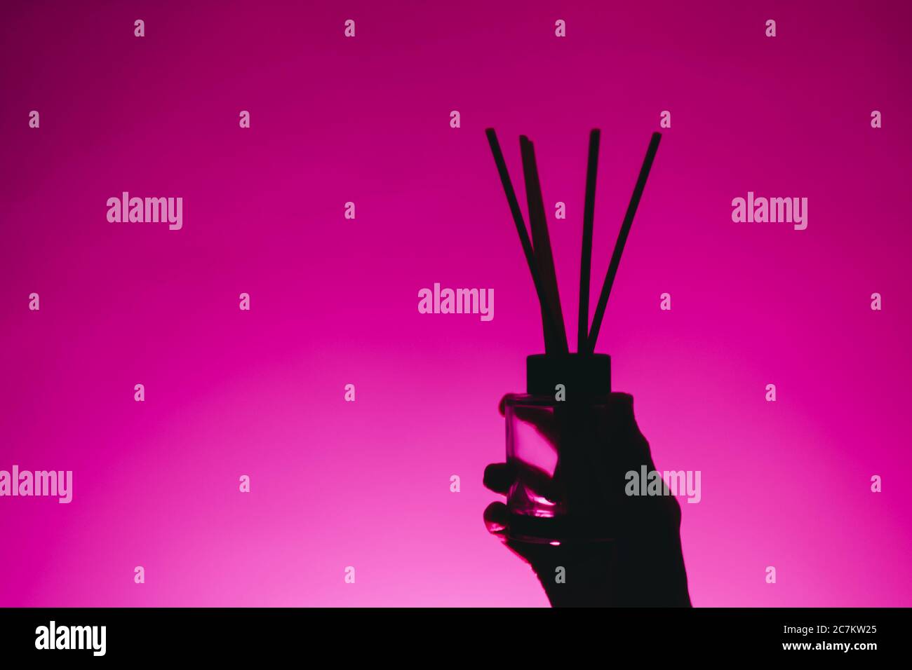 silhouette of aroma diffuser in a female hand isolated on a pink ...