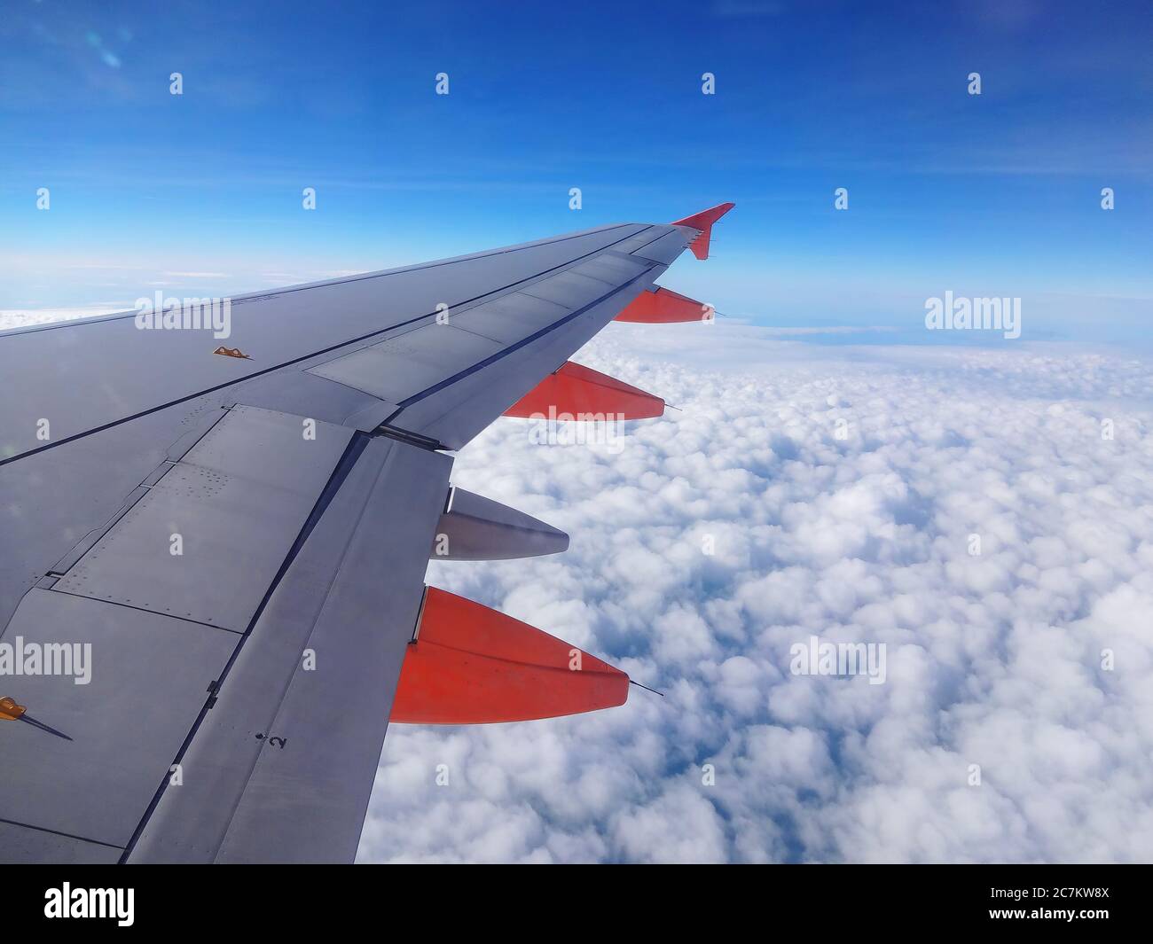 Commercial jet aircraft wing flying above the clouds Stock Photo - Alamy