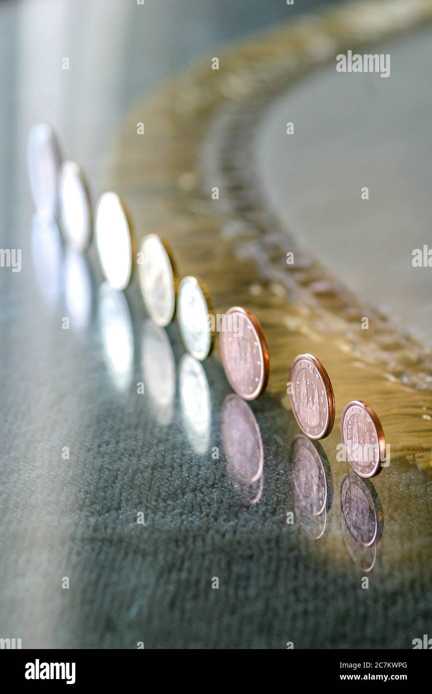 Different Euro coins balance on a glass table Stock Photo - Alamy