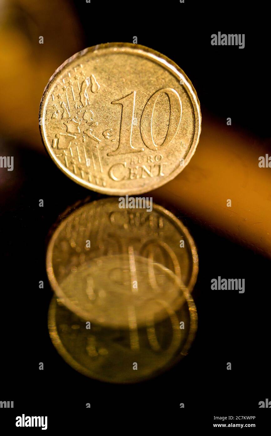 Different Euro coins balance on a glass table Stock Photo - Alamy