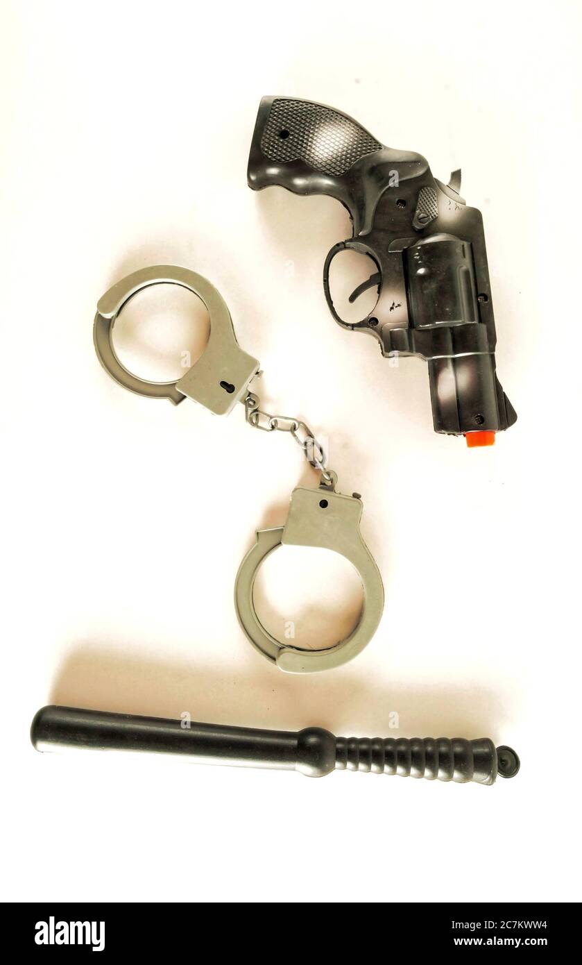Vertical shot of a gun and handcuffs on a white background Stock Photo ...