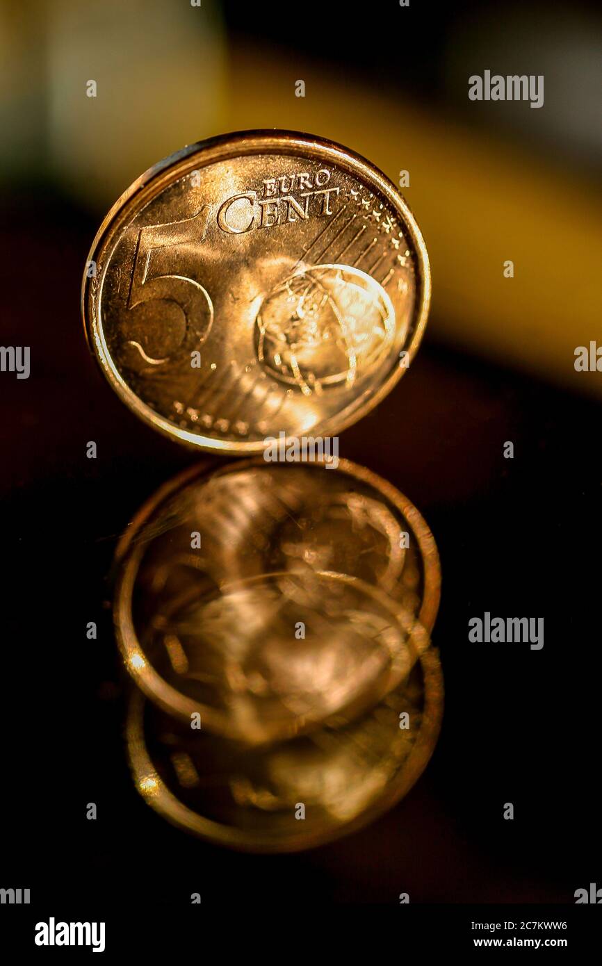Different Euro coins balance on a glass table Stock Photo - Alamy