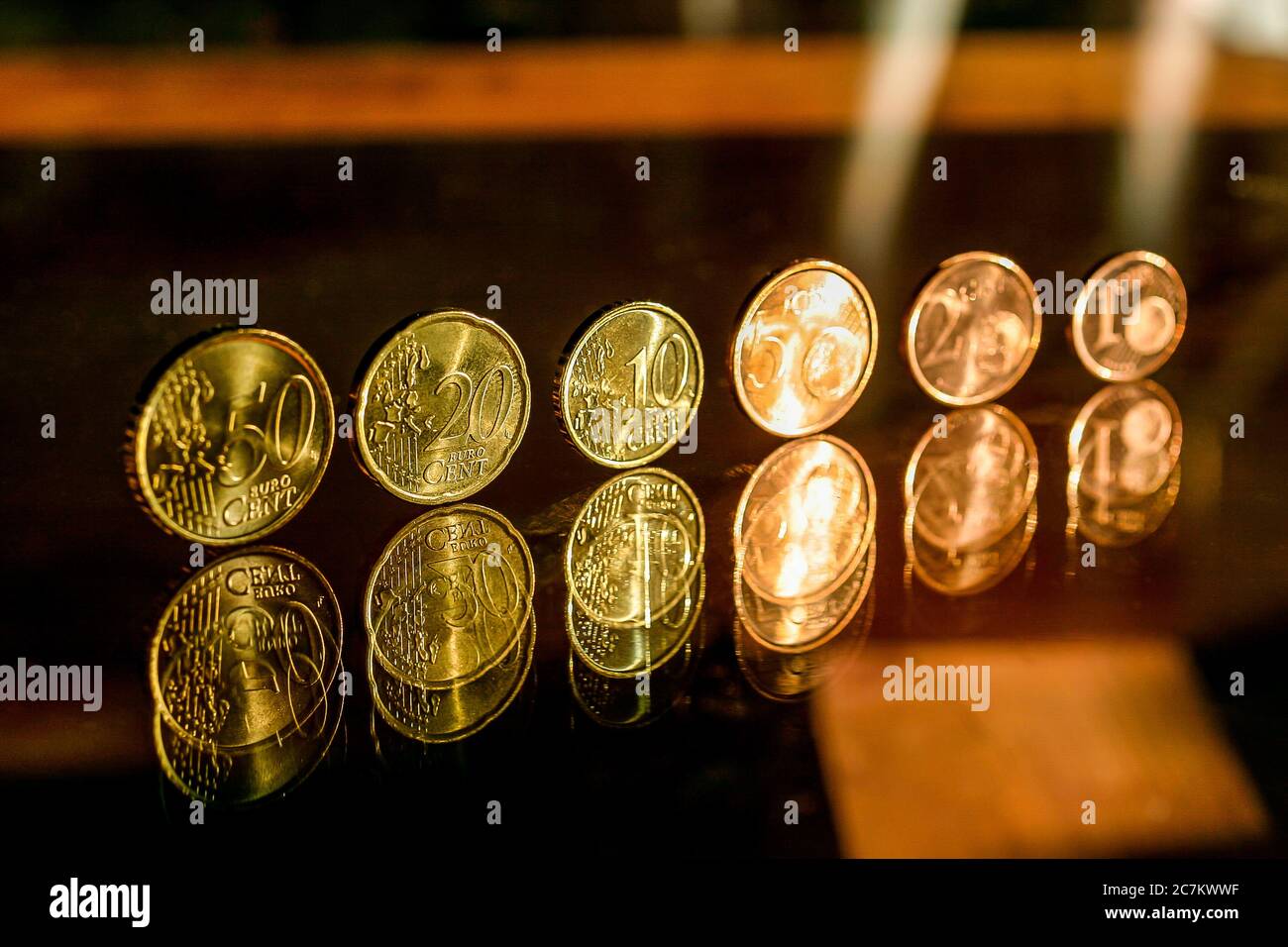 Different Euro coins balance on a glass table Stock Photo - Alamy
