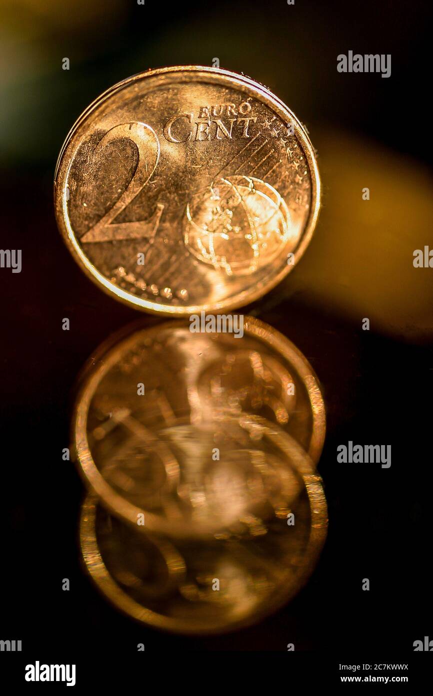 Different Euro coins balance on a glass table Stock Photo - Alamy